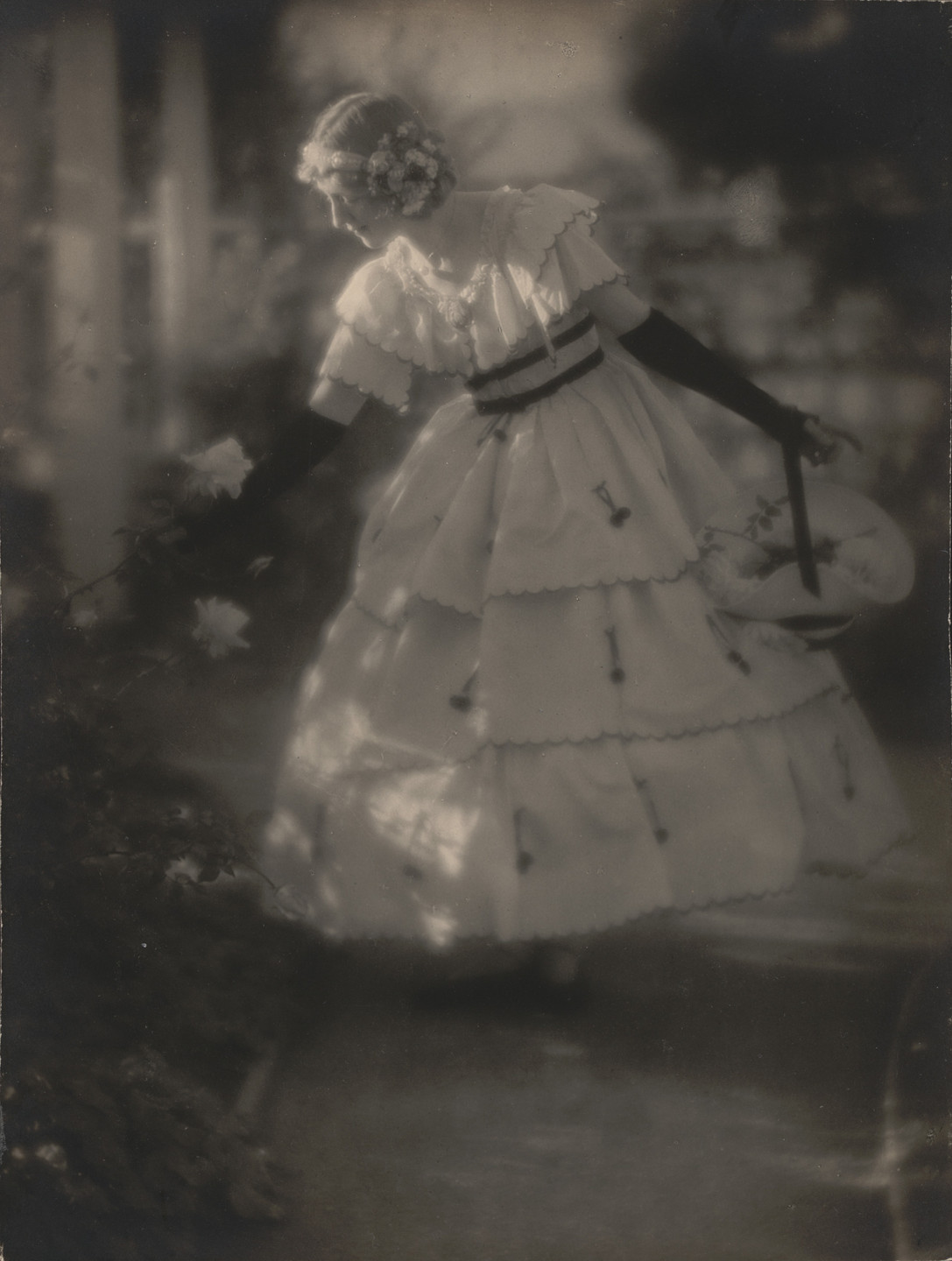 Edward Weston. Violet Romer. (in hoop skirt admiring rose). c. 1917 | MoMA